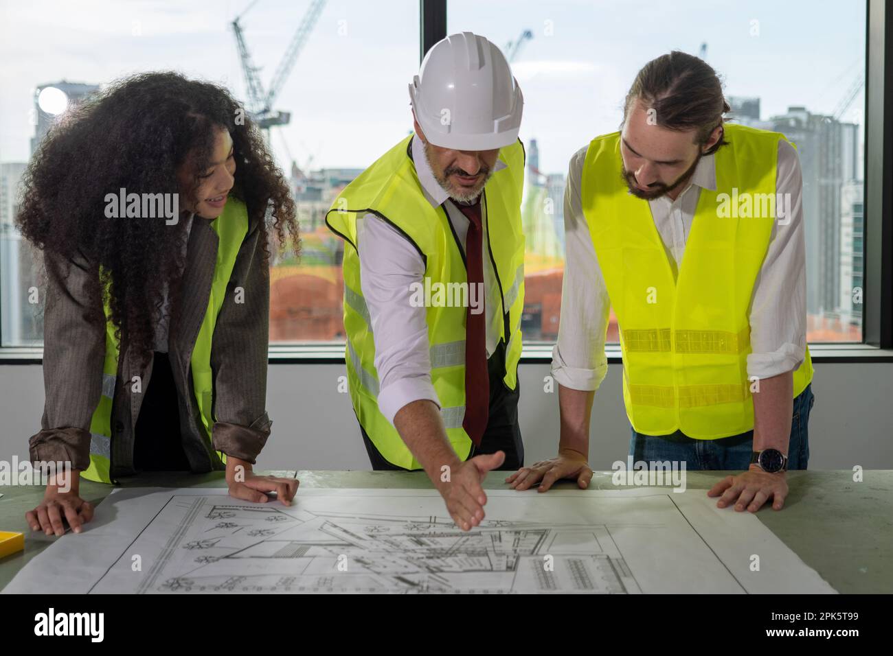 Professional construction engineers team using blueprint of project ...