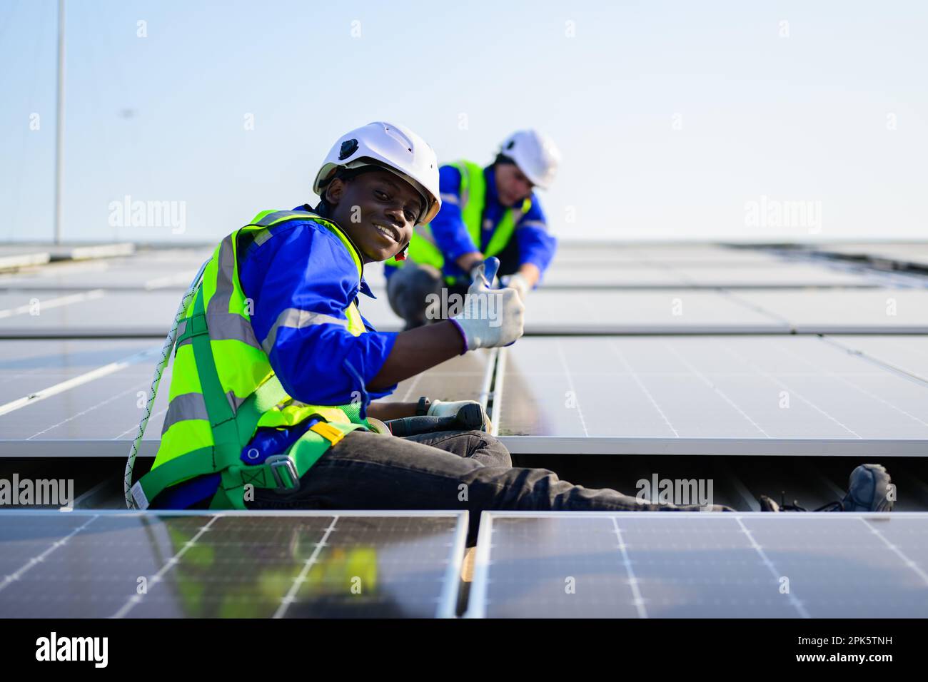 Professional technicians installing solar panels on rooftop of plant ...