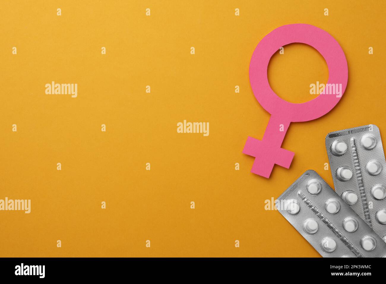 Female gender sign, blisters of pills and space for text on orange ...
