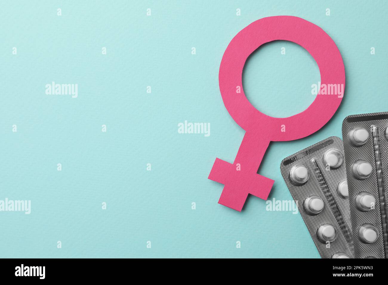 Female gender sign, blisters of pills and space for text on turquoise ...