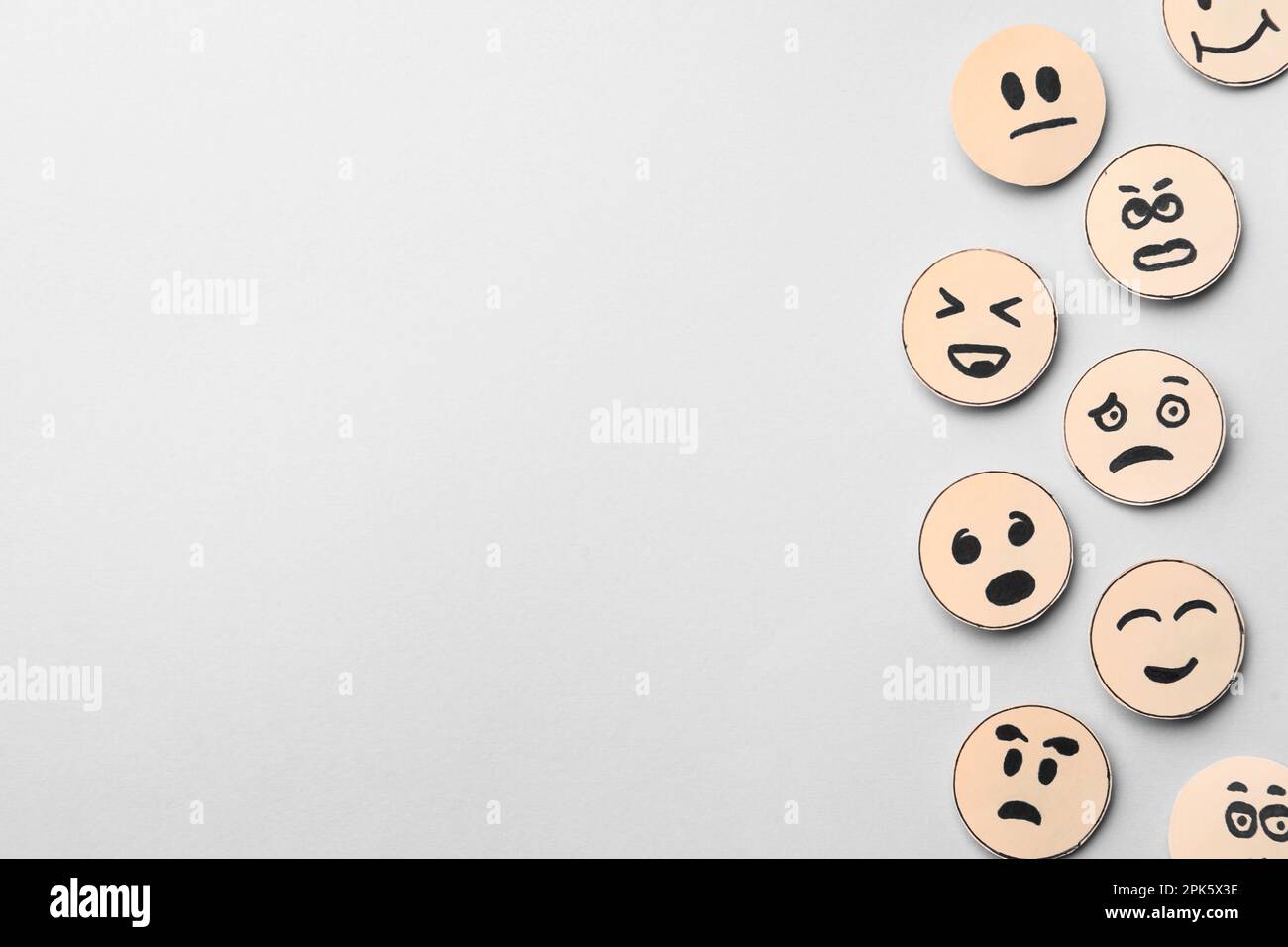 Many faces with different emotions on grey background, flat lay. Space ...