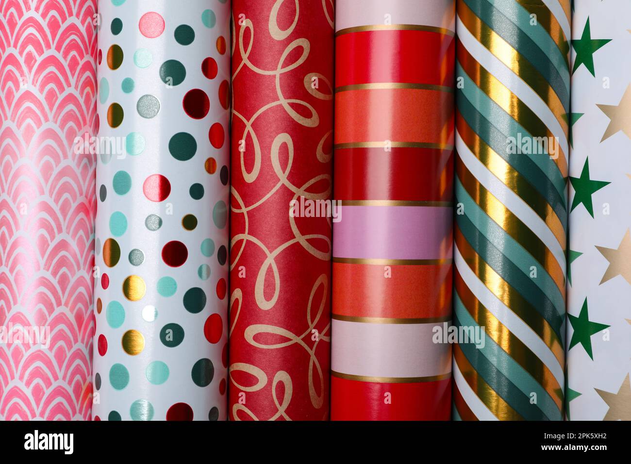 Different colorful wrapping paper rolls as background, top view Stock ...
