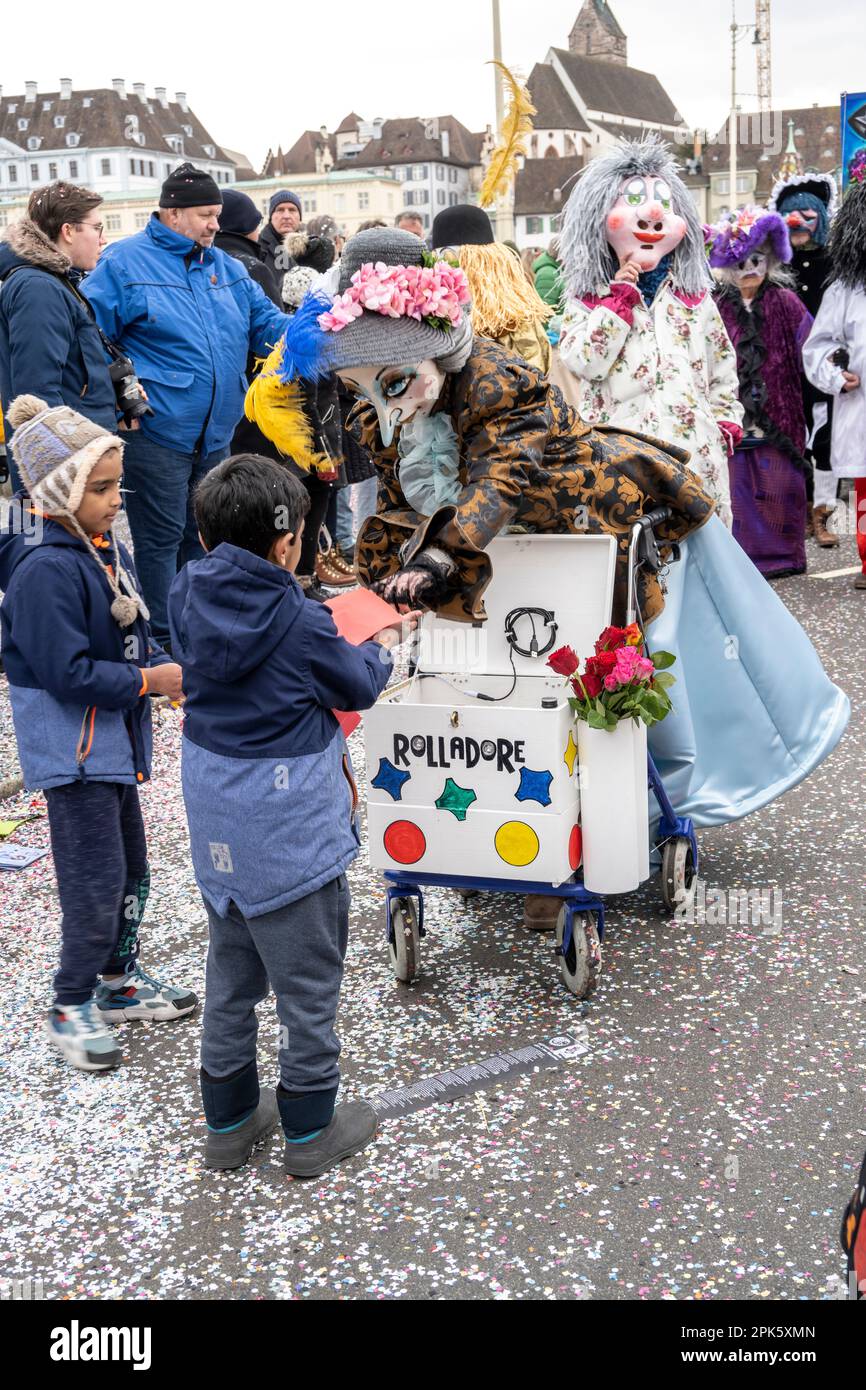Old Aunt Costume at the Basel Fasnacht parade in Switzerland handing ...