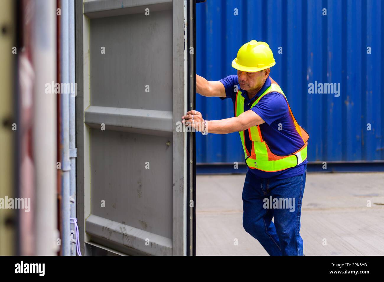Logistics worker opening and closing door of container box at warehouse ...
