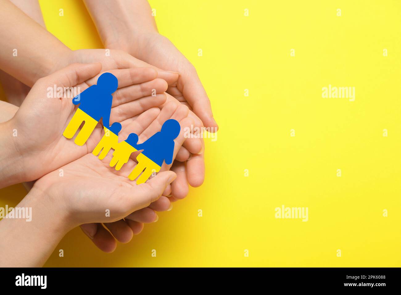 People holding paper family cutout in colors of Ukrainian flag on ...