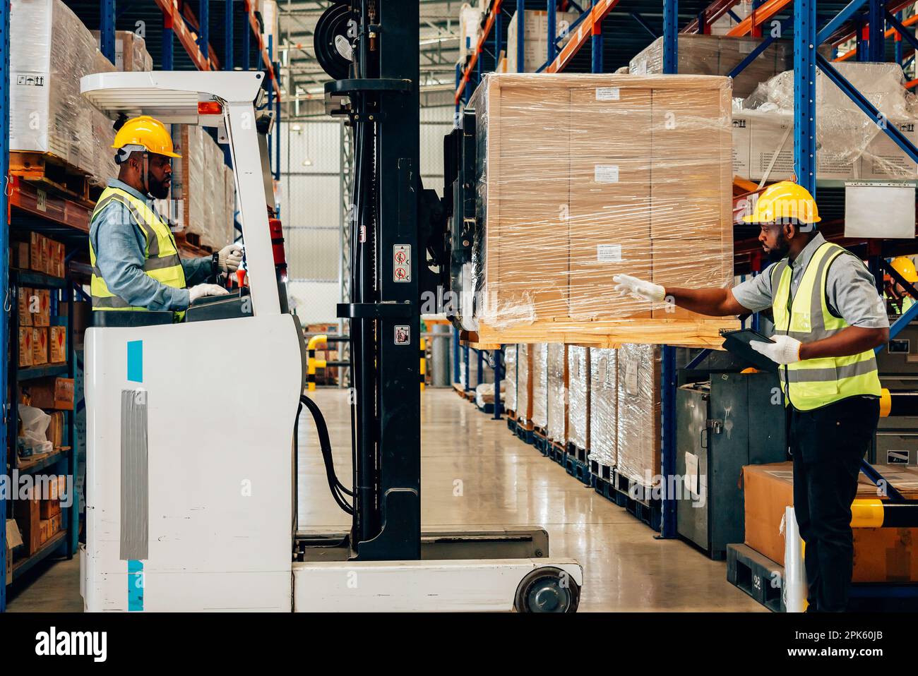 Professional warehouse worker moving cardboard boxes by forklift ...