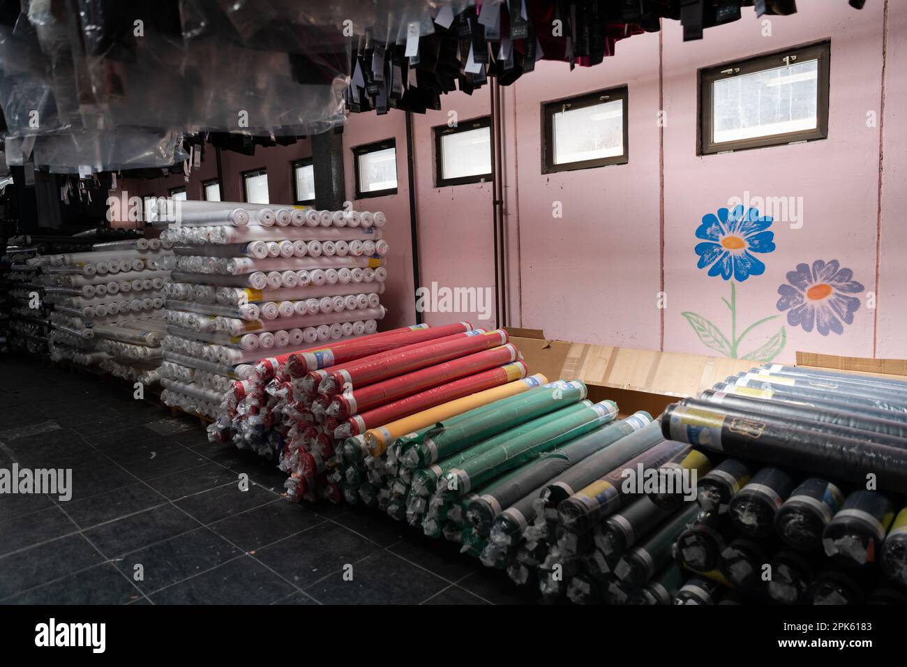 Interior of an industrial warehouse with fabric rolls samples. Small ...