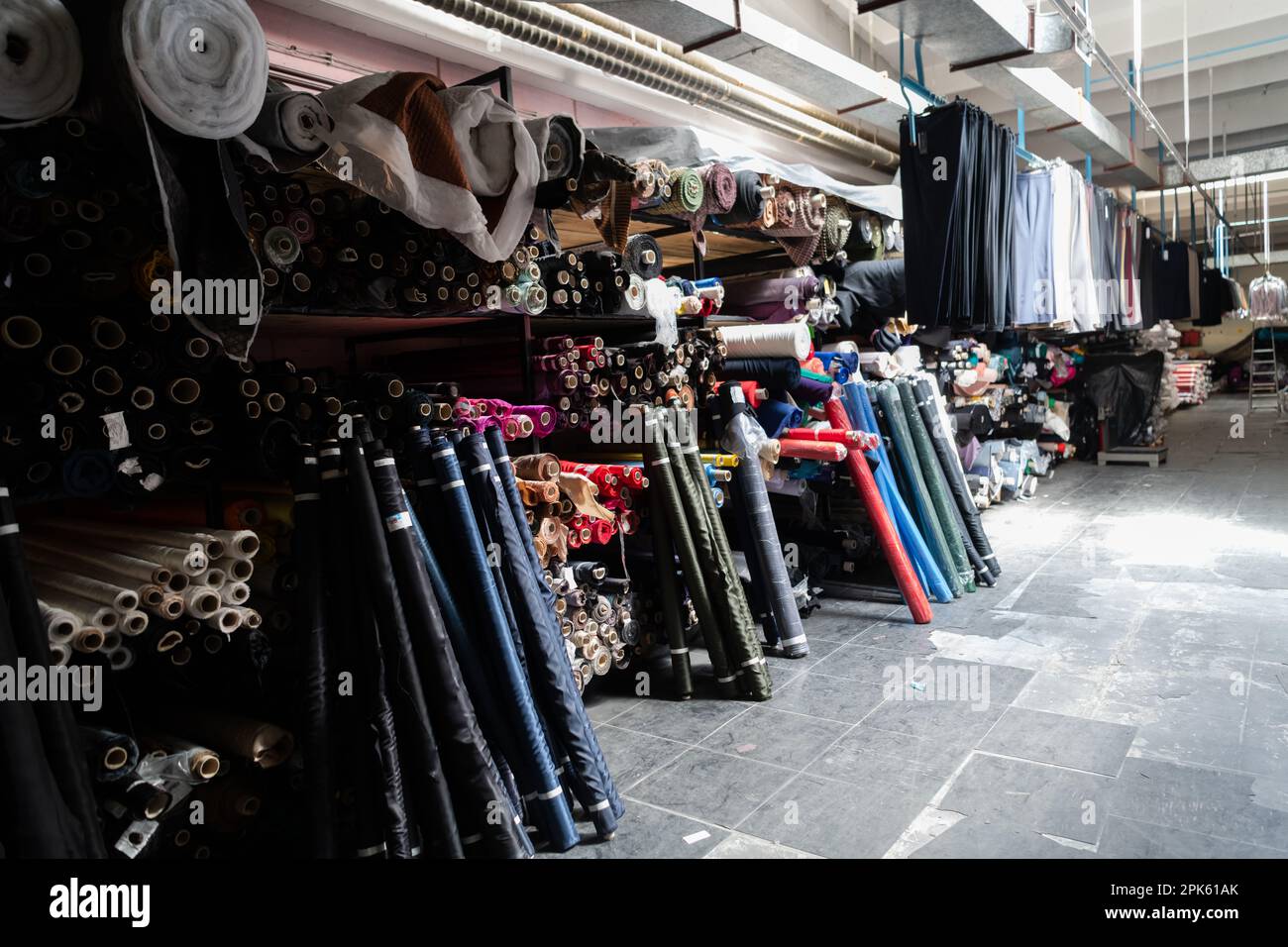Interior of an industrial warehouse with fabric rolls samples. Small ...