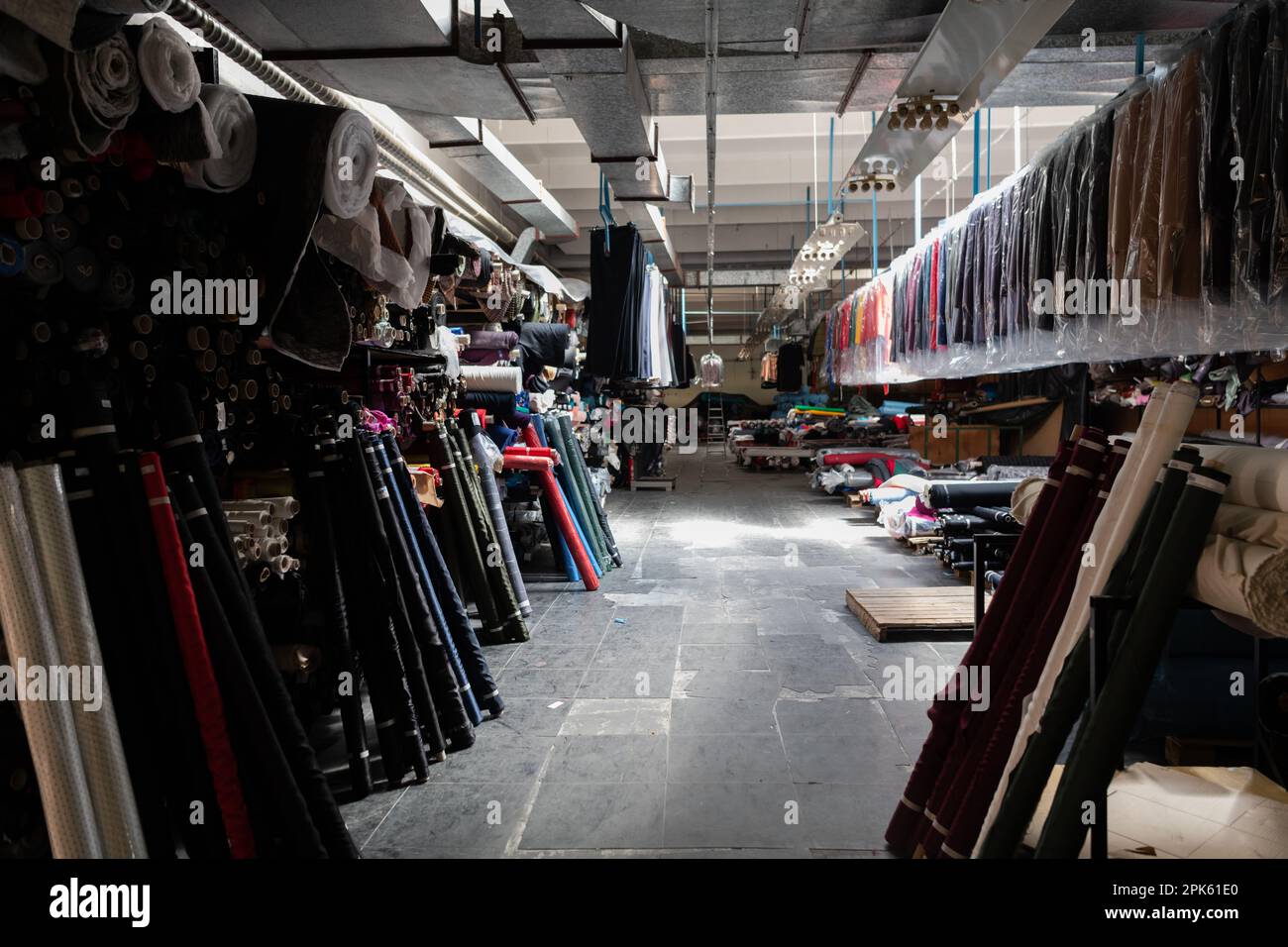 Interior of an industrial warehouse with fabric rolls samples. Small ...