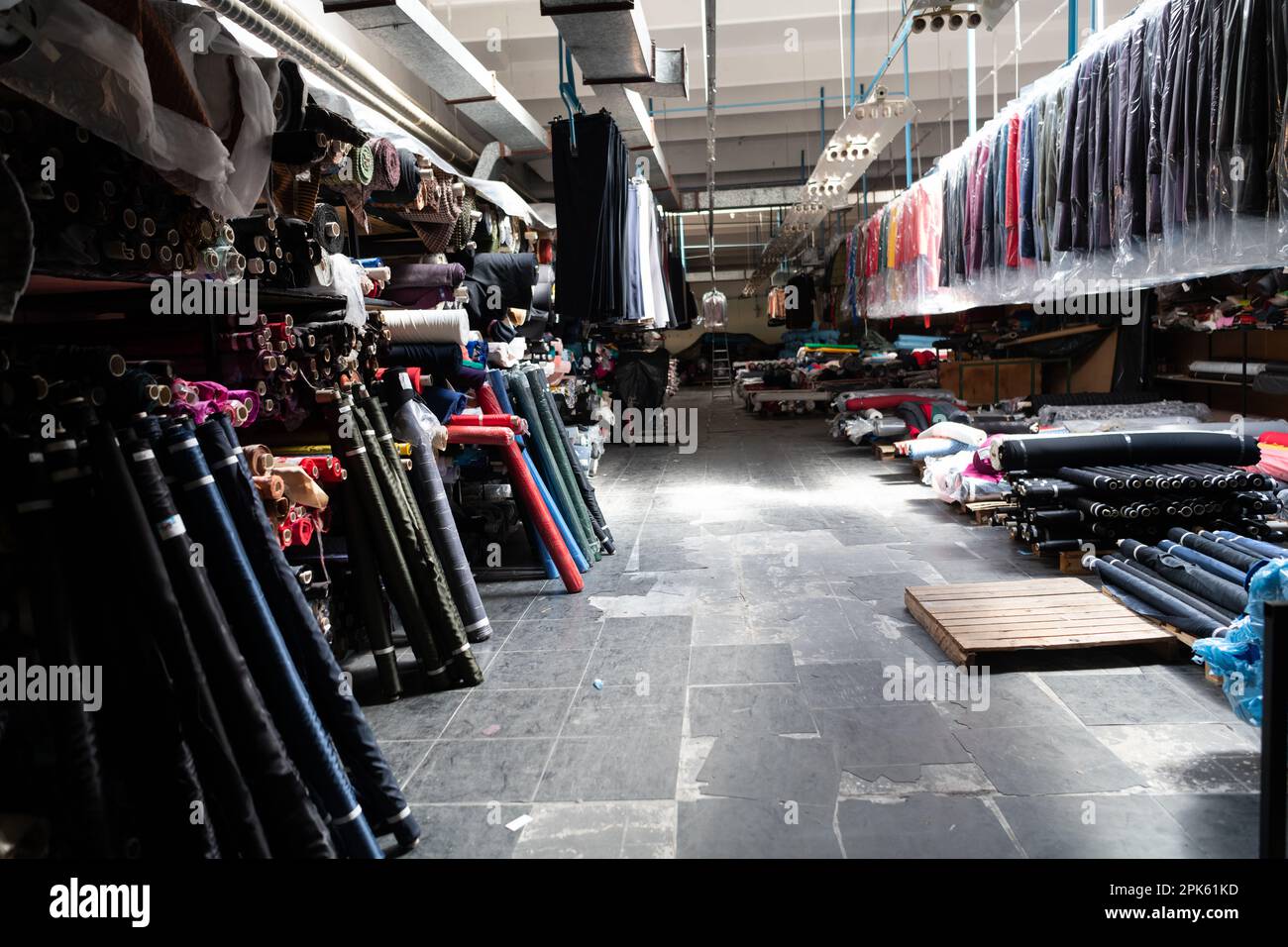 Interior of an industrial warehouse with fabric rolls samples. Small ...