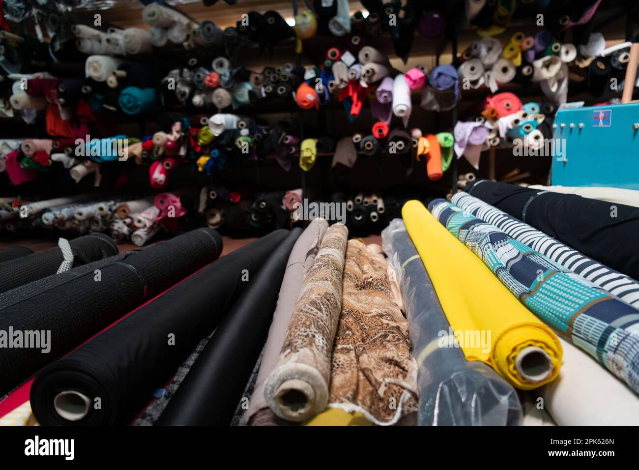 Interior of an industrial warehouse with fabric rolls samples. Small ...