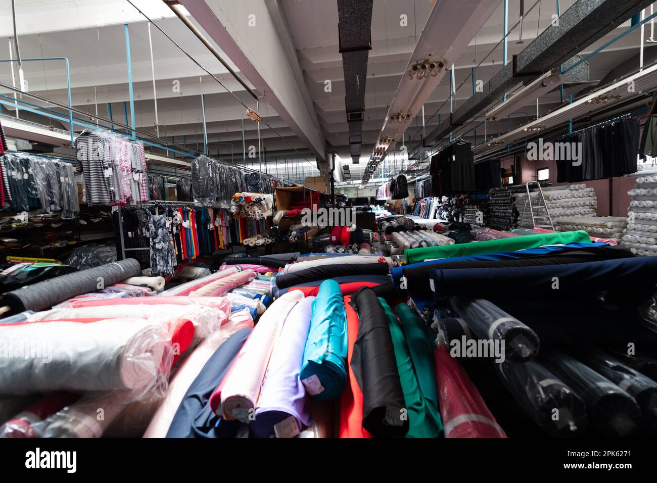 Interior of an industrial warehouse with fabric rolls samples. Small ...