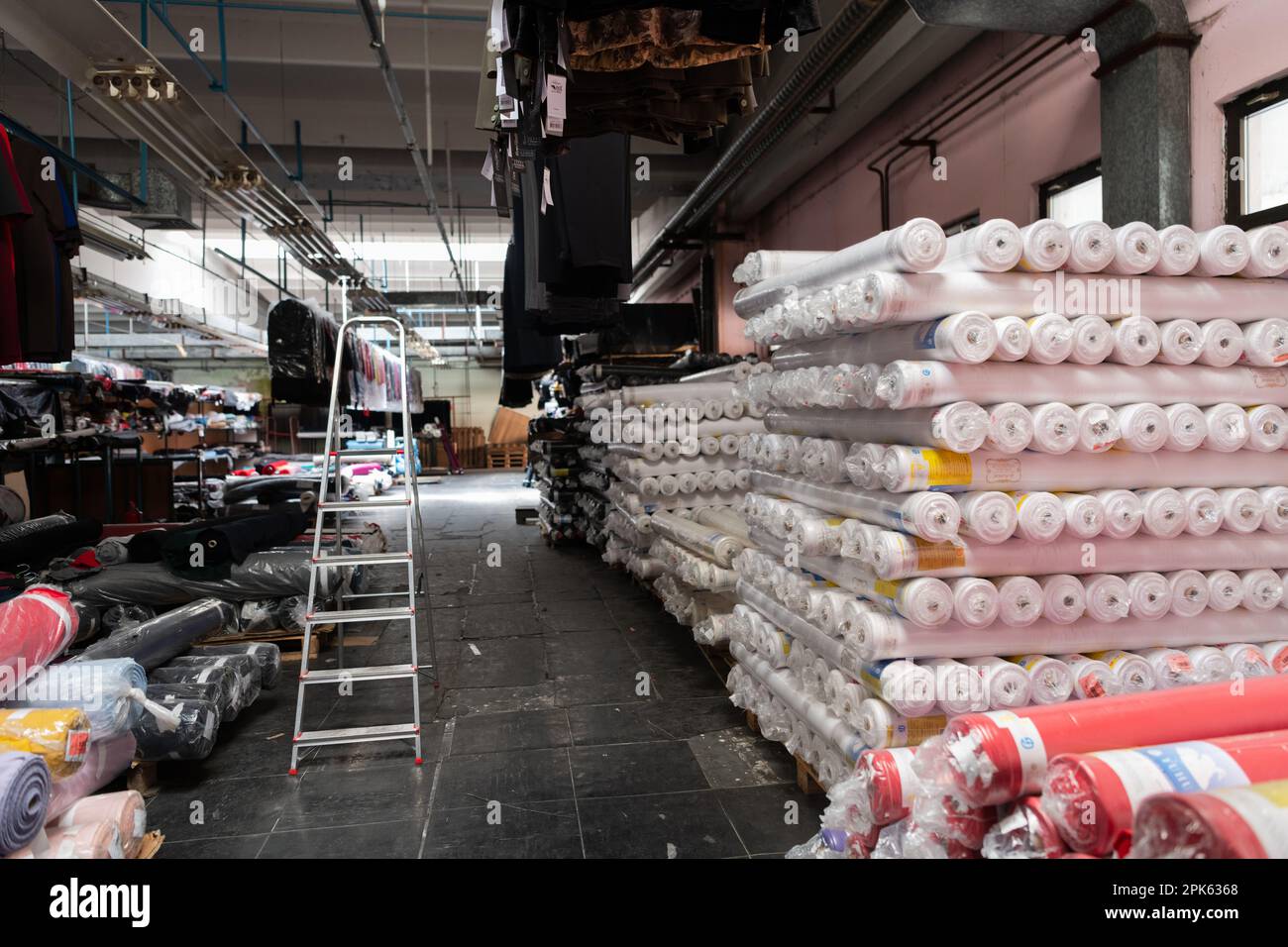 Interior of an industrial warehouse with fabric rolls samples. Small ...