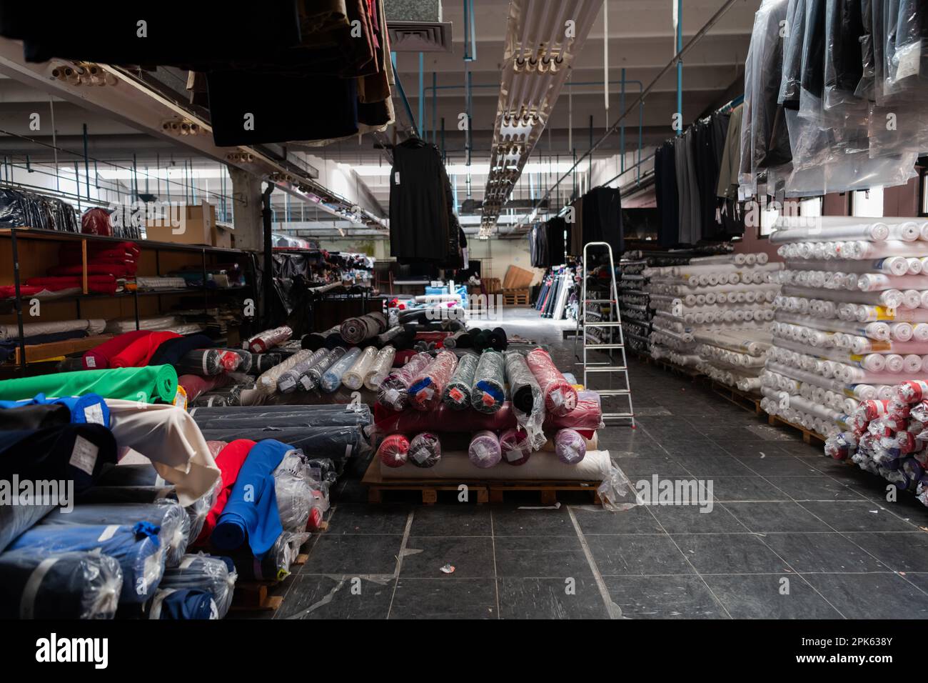 Interior of an industrial warehouse with fabric rolls samples. Small ...