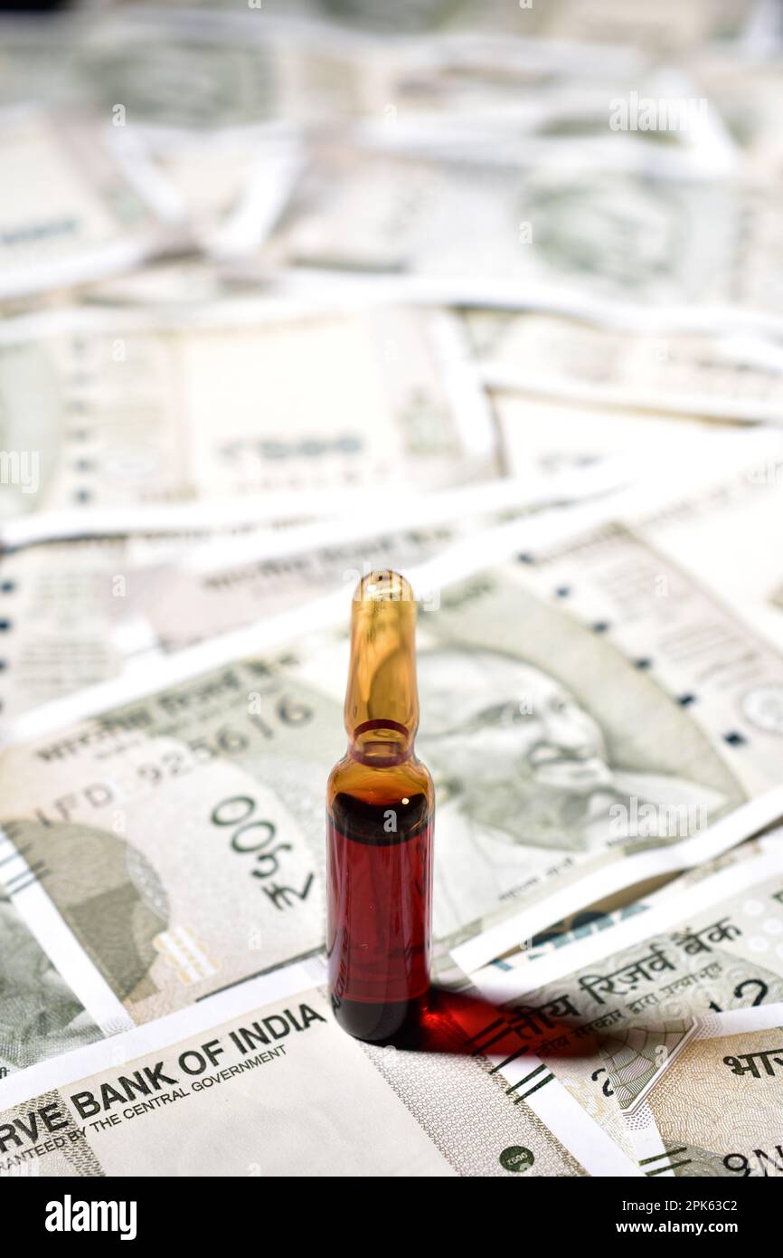Vertical view of injection vial with indian rupees Stock Photo - Alamy
