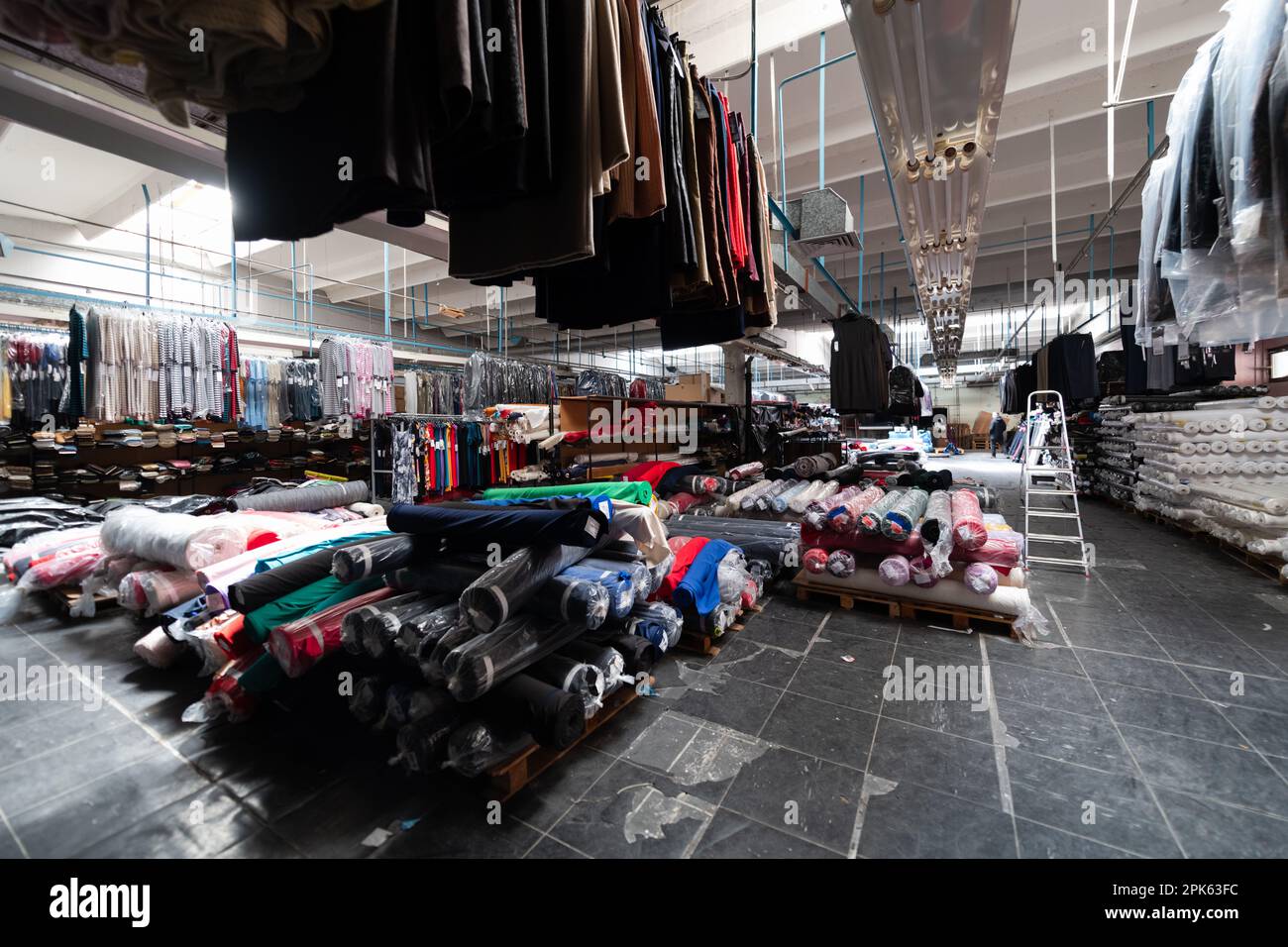 Interior of an industrial warehouse with fabric rolls samples. Small ...