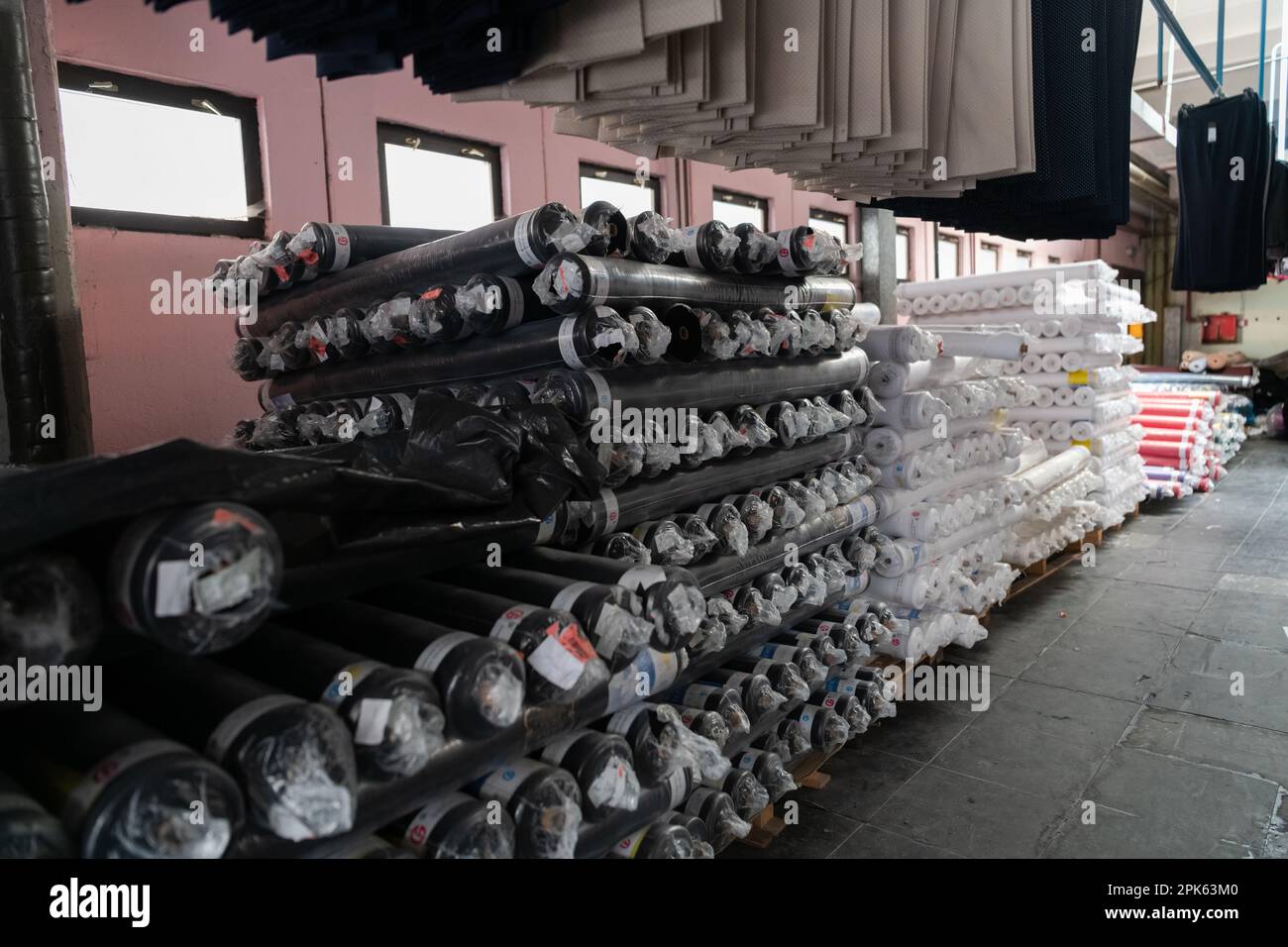 Interior of an industrial warehouse with fabric rolls samples. Small ...