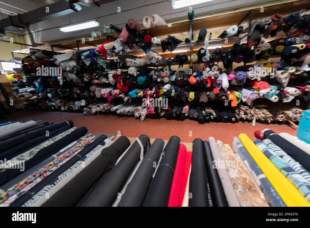 Interior of an industrial warehouse with fabric rolls samples. Small ...