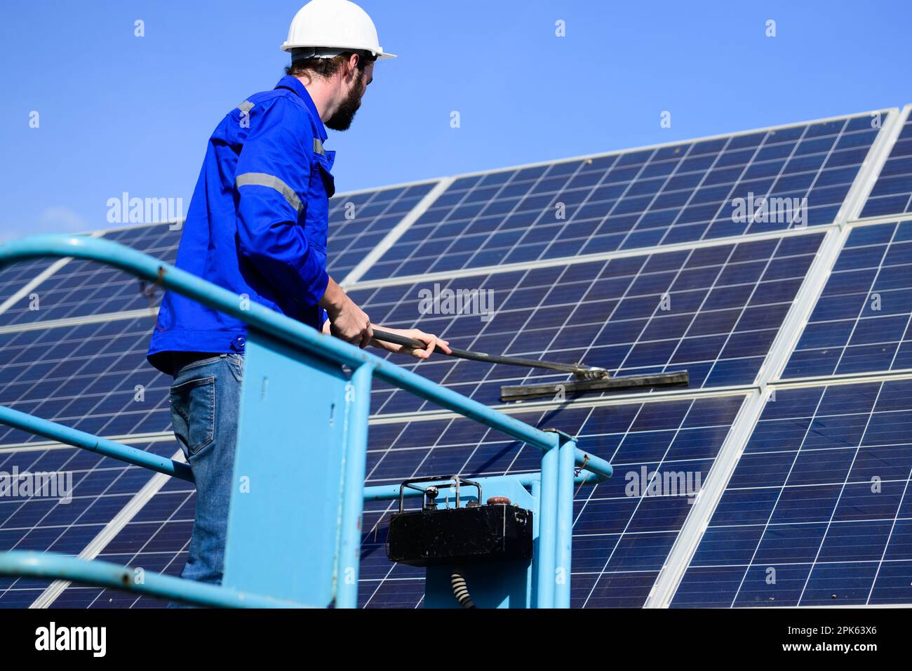 Worker cleaning solar panel at solar cell farm Stock Photo - Alamy