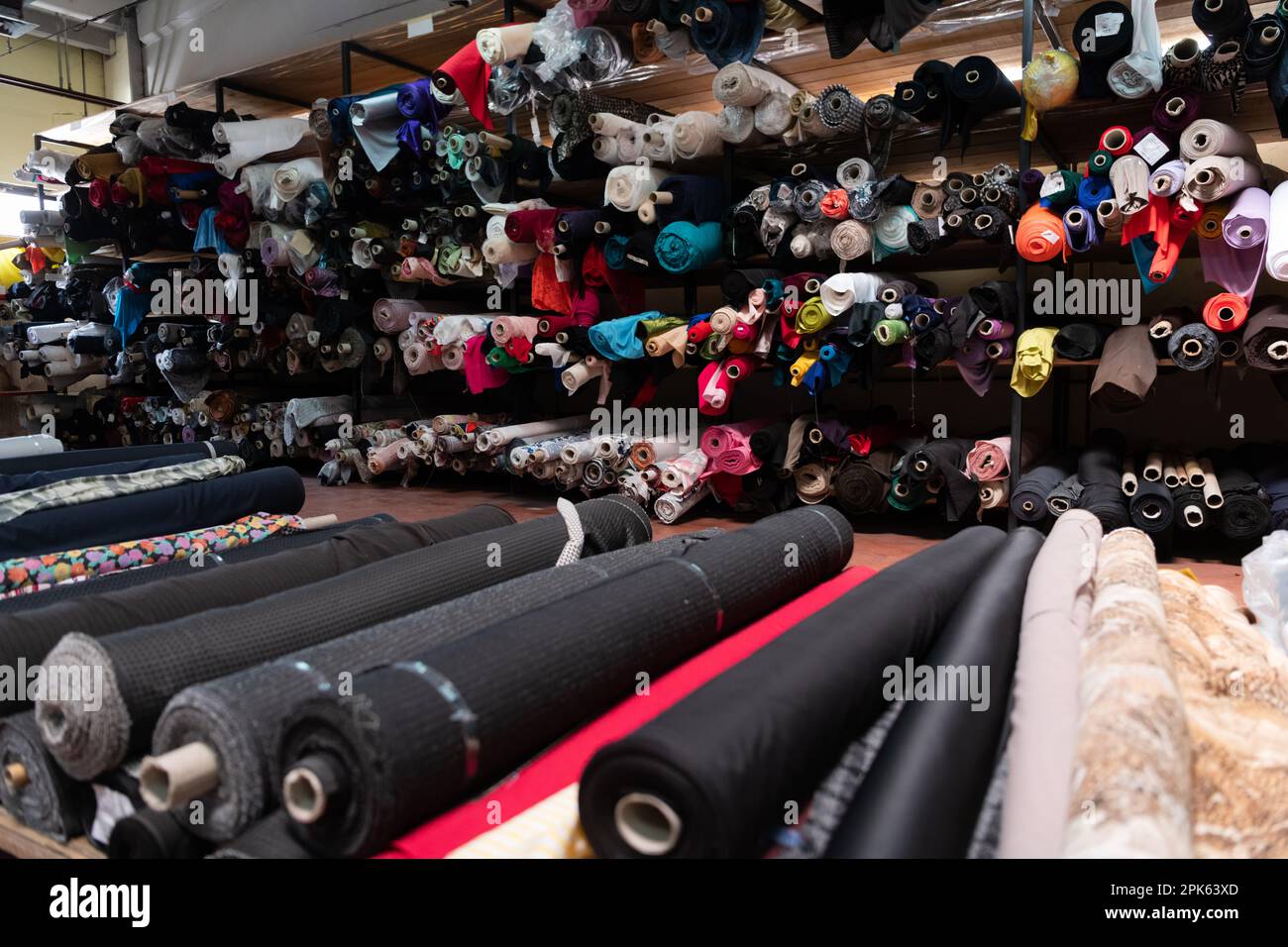 Interior of an industrial warehouse with fabric rolls samples. Small ...
