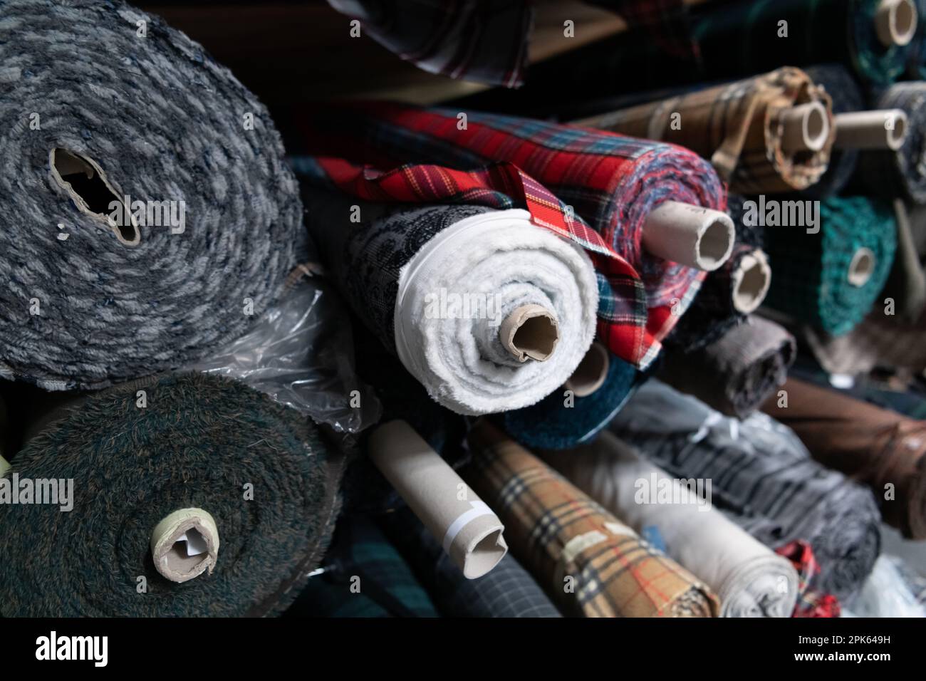 Interior of an industrial warehouse with fabric rolls samples. Small ...