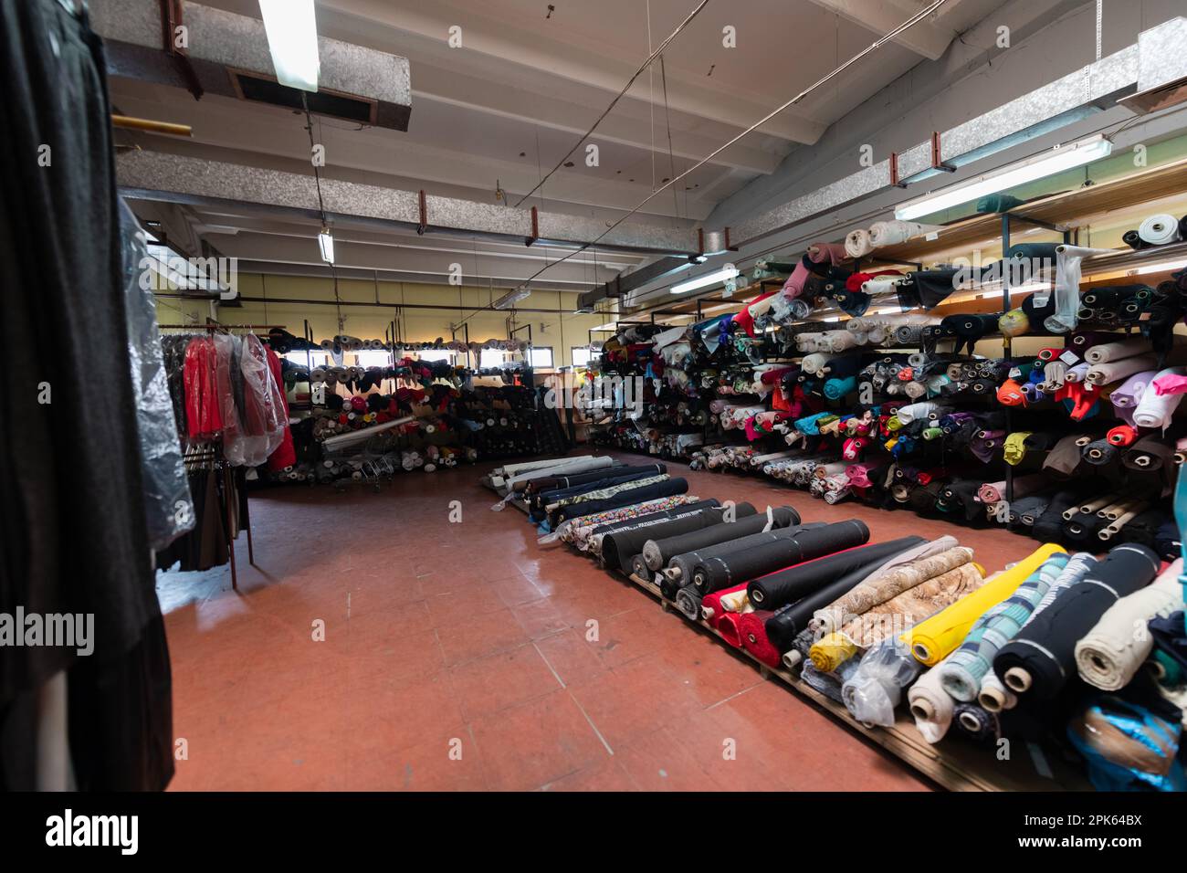 Interior of an industrial warehouse with fabric rolls samples. Small ...