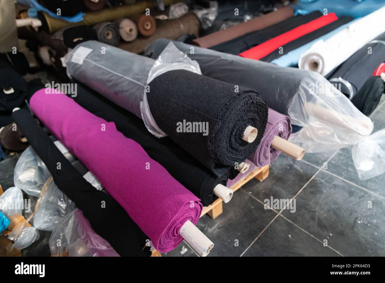 Interior of an industrial warehouse with fabric rolls samples. Small ...