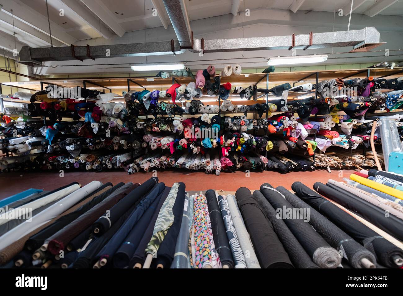 Interior of an industrial warehouse with fabric rolls samples. Small ...
