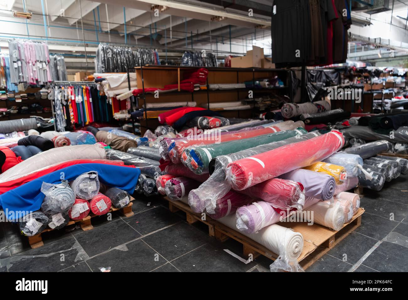Interior of an industrial warehouse with fabric rolls samples. Small ...