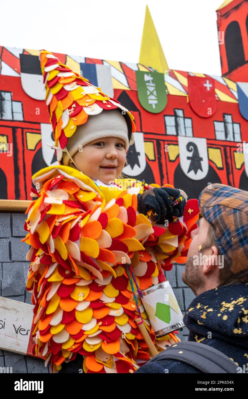 young girl in harlequin with Costume with candy at the Basel Fasnacht ...