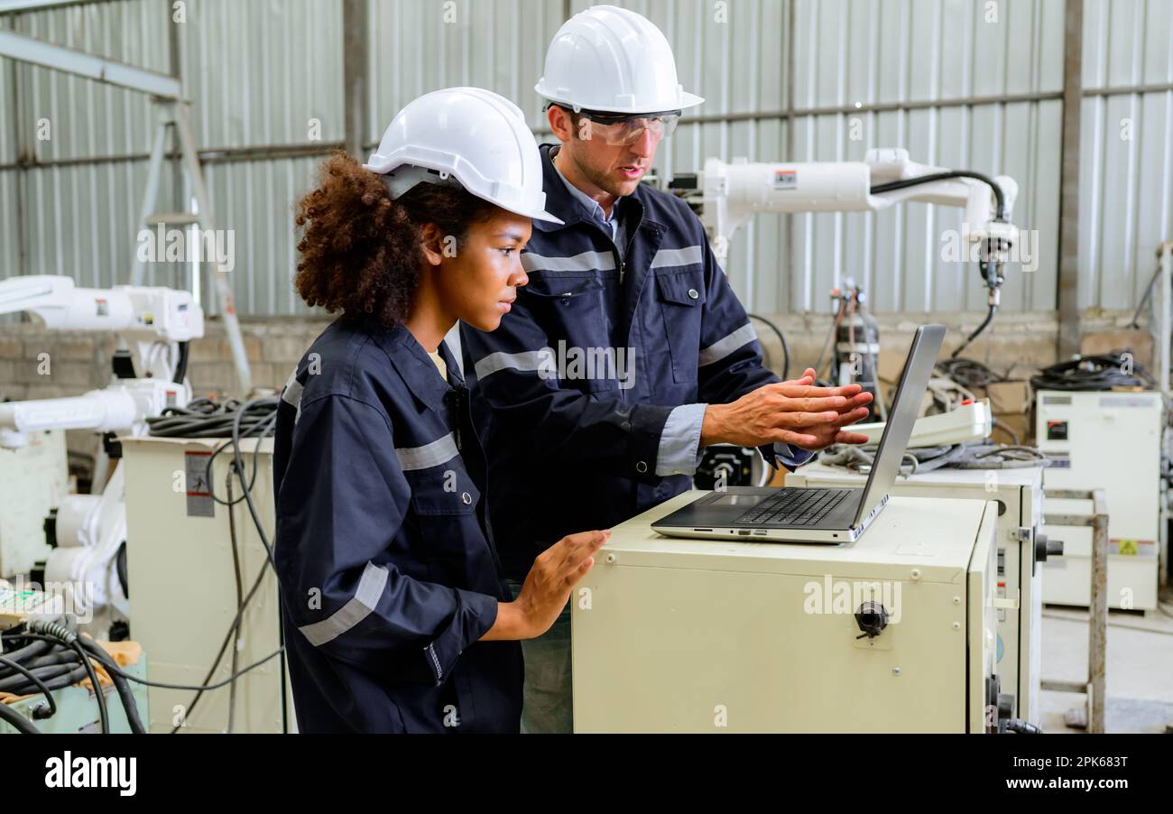 Engineers technicians controlling robotic arms on computer laptop at ...