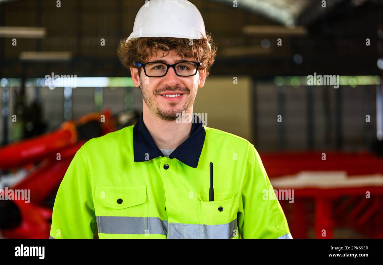 Portrait of engineer checking and inspecting machine at industrial ...