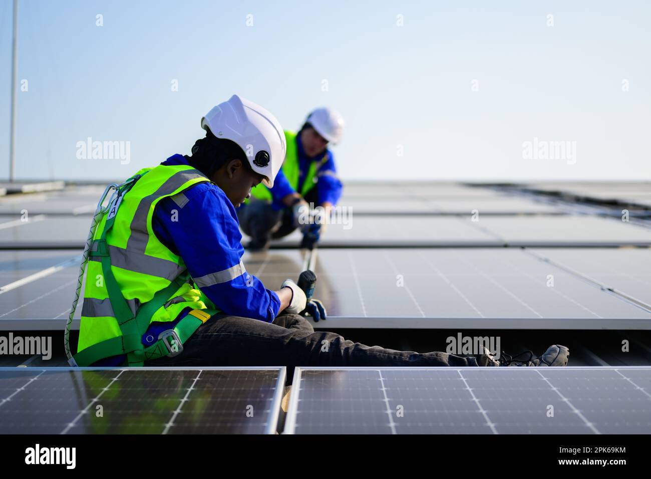 Professional technicians installing solar panels on rooftop of plant ...