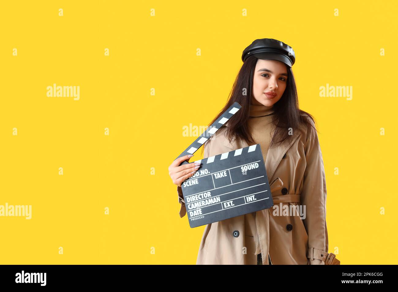 Female film director with movie clapper on yellow background Stock ...