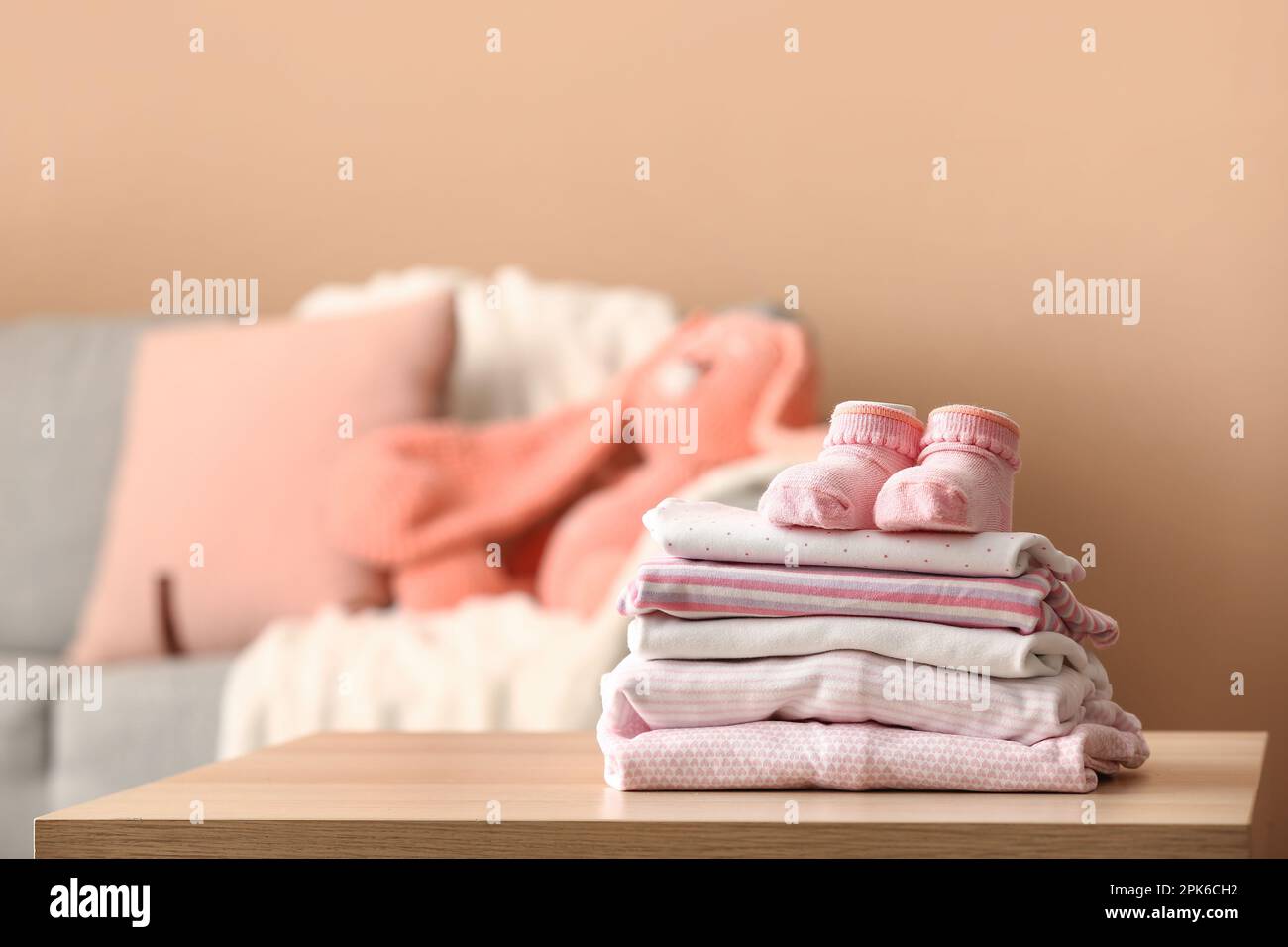 Stack of baby clothes and socks on table in room Stock Photo - Alamy