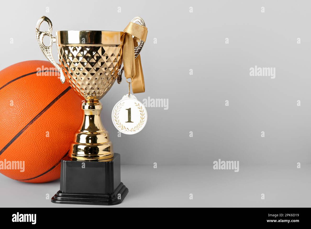 Gold cup with first place medal and ball on light background Stock ...
