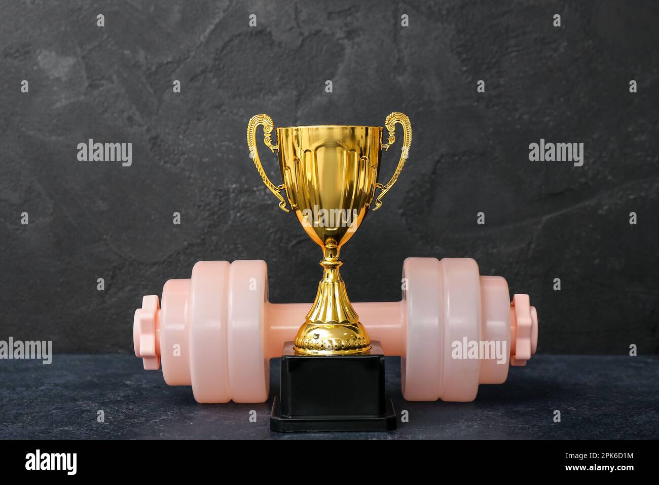 Gold cup with dumbbell on dark background Stock Photo - Alamy