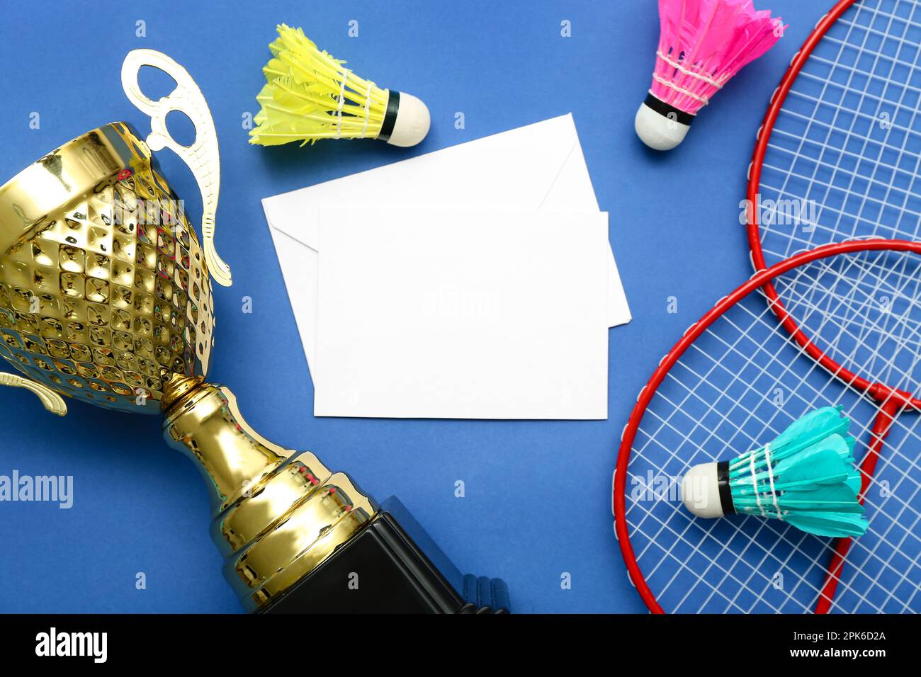 Blank card with gold cup and badminton equipment on blue background ...