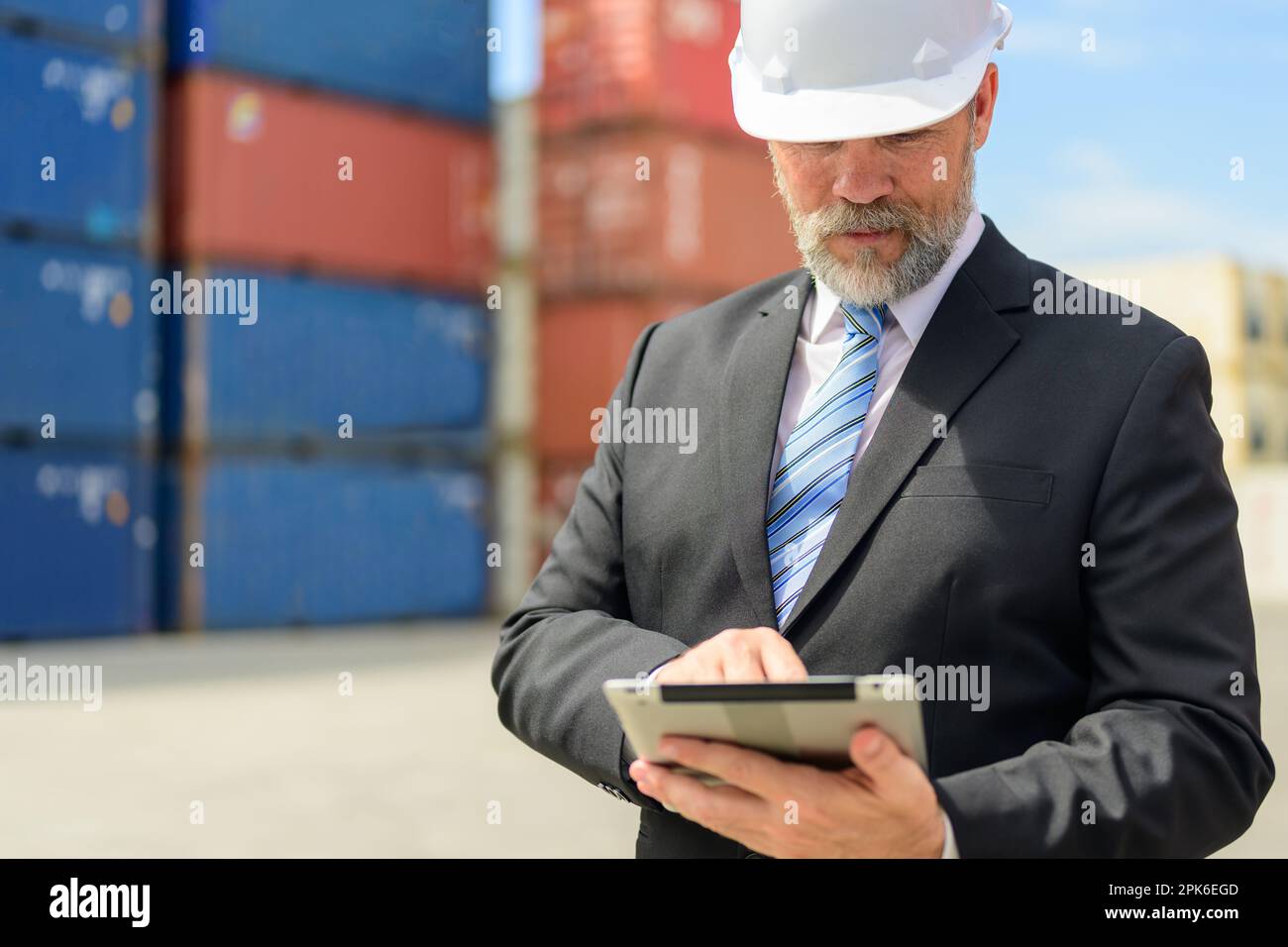 Smart businessman in black suit holding tablet checking goods at cargo ...