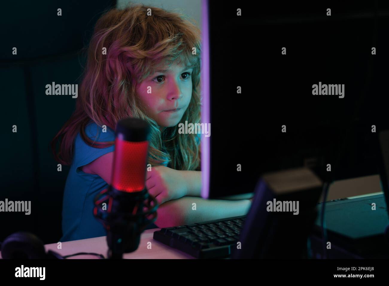 Little child gamer play computer game on desktop. Gaming stream and ...