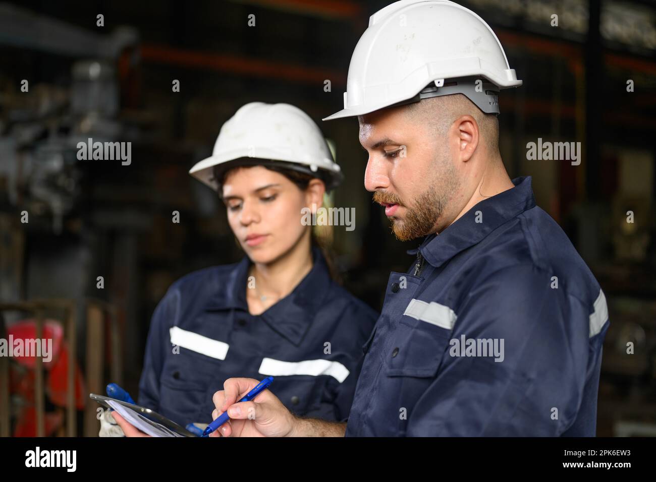 Two mechanical engineer in white hard hat talking Stock Photo - Alamy