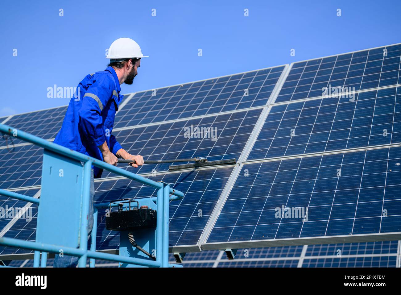 Worker cleaning solar panel at solar cell farm Stock Photo - Alamy