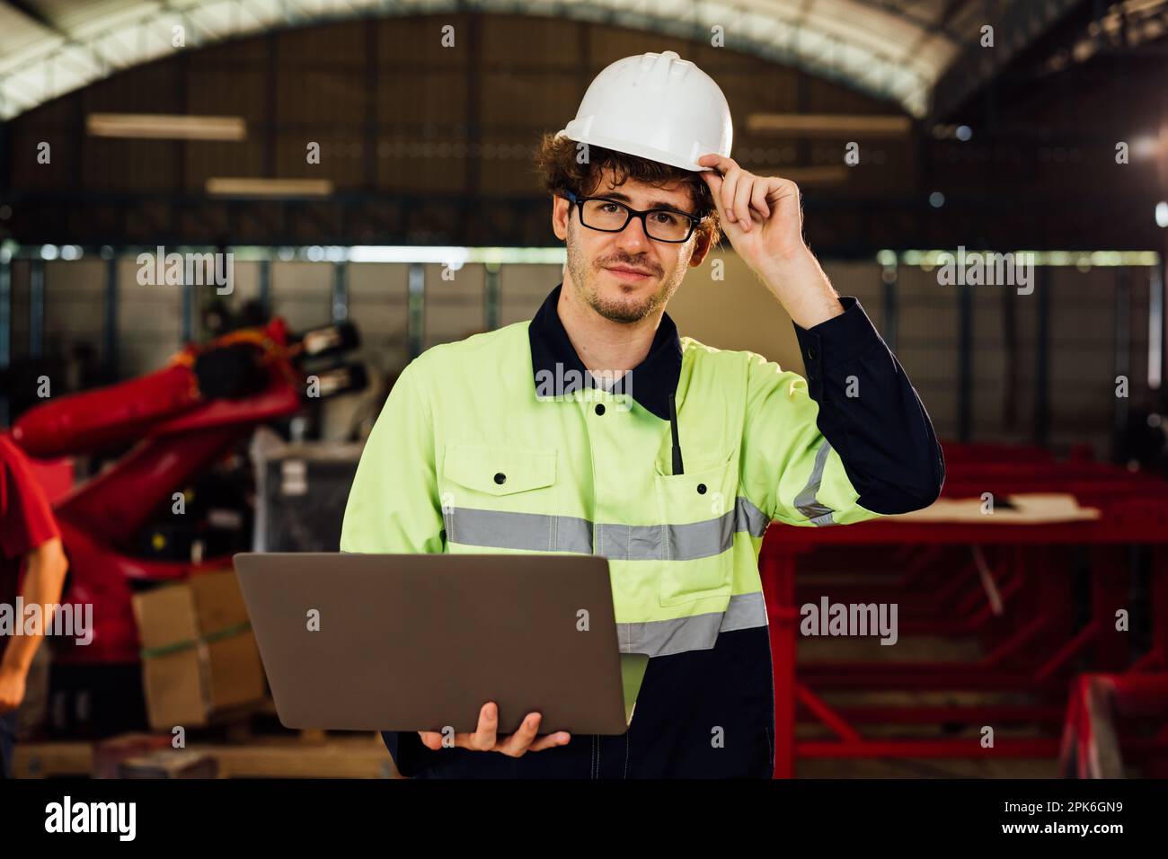 Portrait of happy male mechanical engineer in white hard hat and safety ...