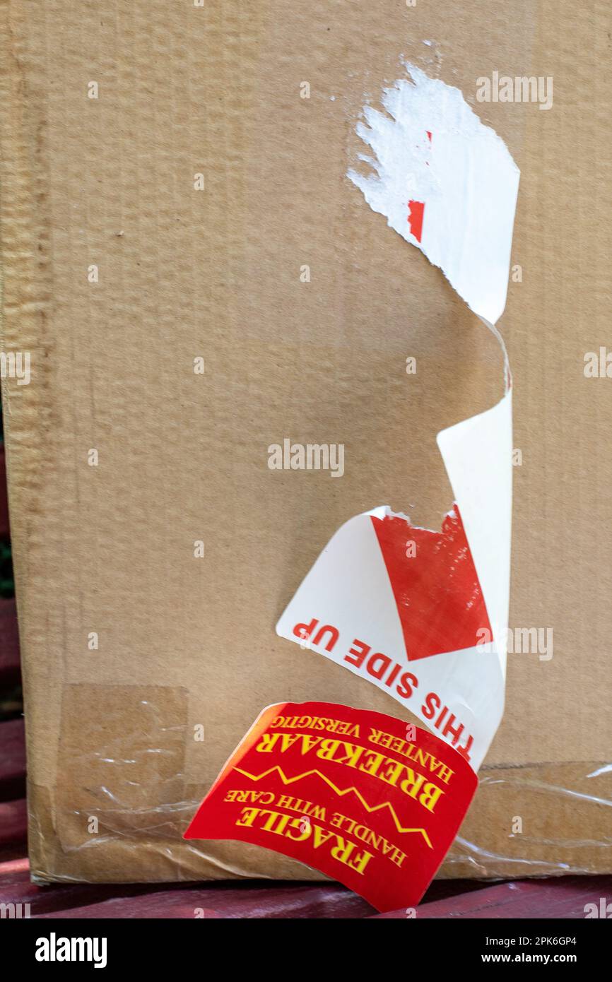 A handle with care and fragile label torn from the side of a cardboard ...