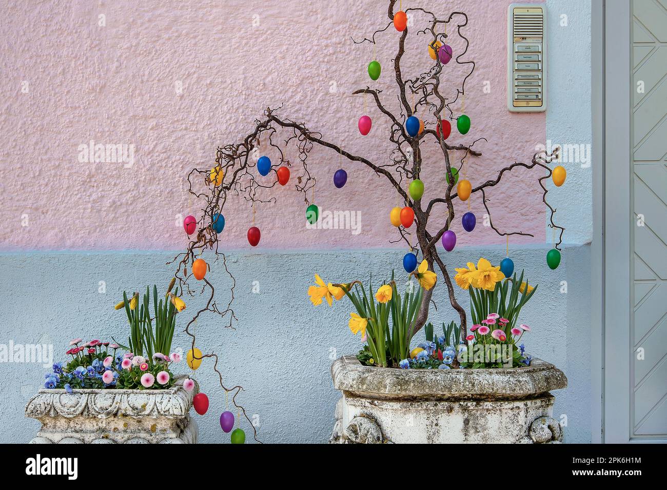 Easter eggs and spring flowers in front of pink house wall, Munich ...
