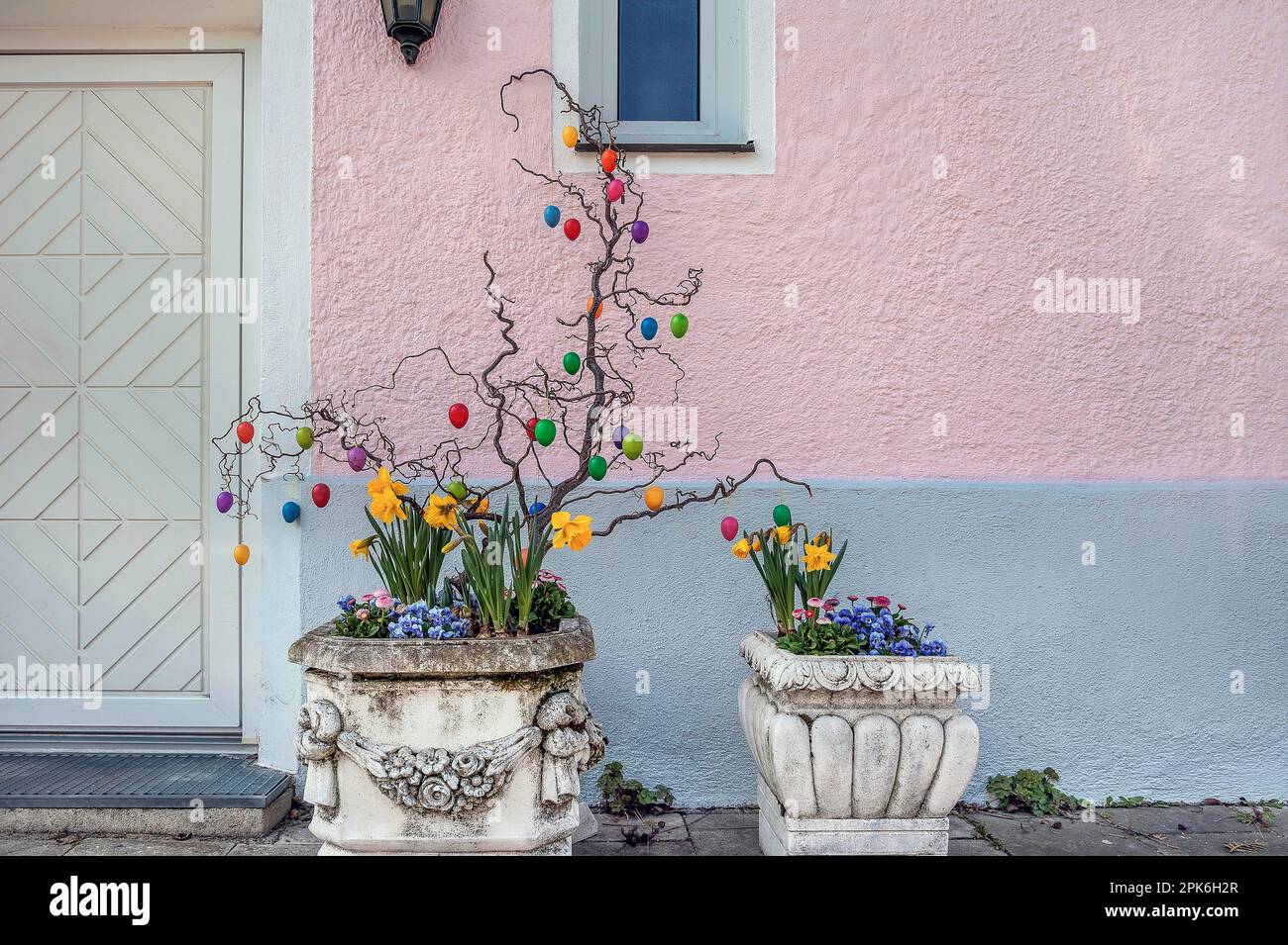 Easter eggs and spring flowers in front of pink house wall, Munich ...