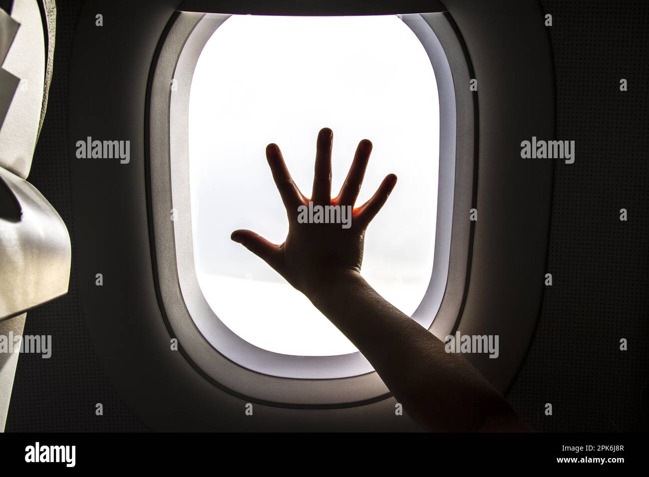 Aircraft window and hand of a child Stock Photo - Alamy