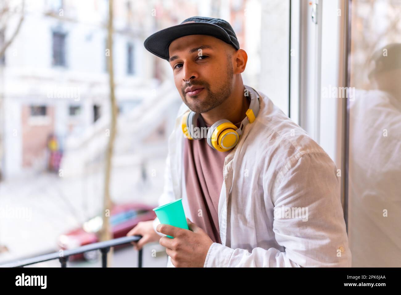 Portrait of a young man of Latino ethnicity on a balcony at home ...