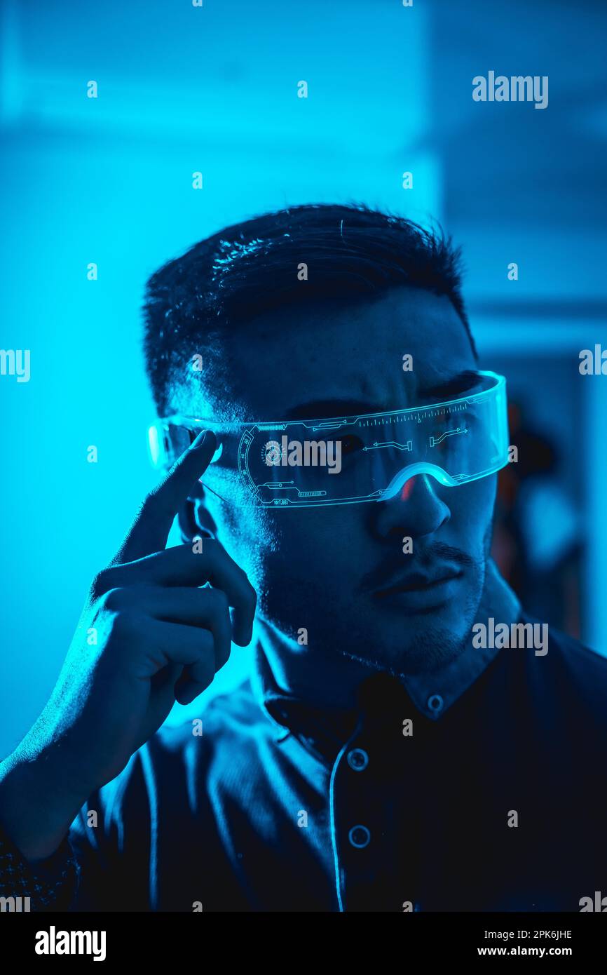 Portrait of young chinese man with neon glasses with a blue light ...
