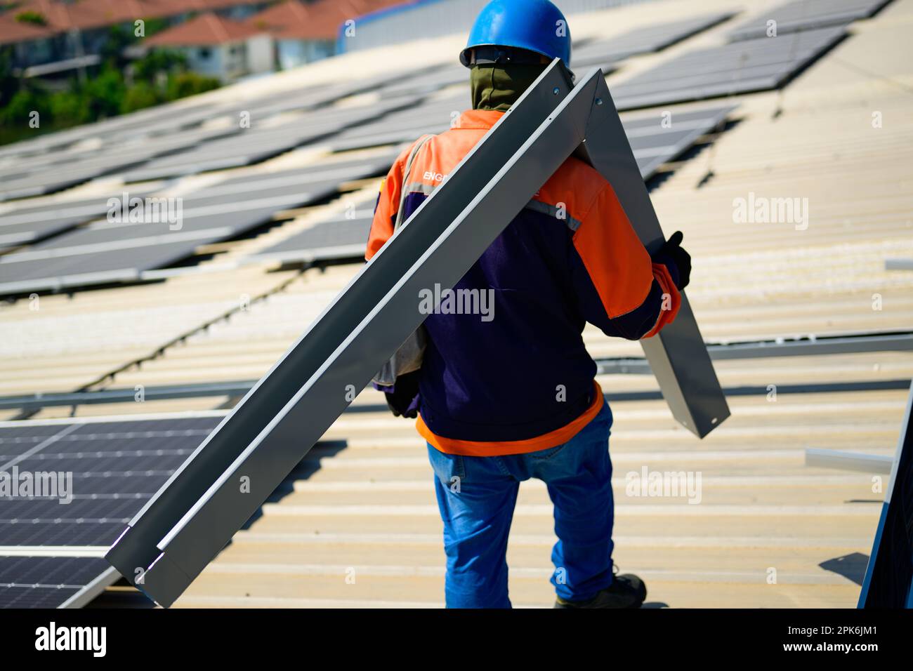 Male technician worker installing solar panels on rooftop of industrial ...